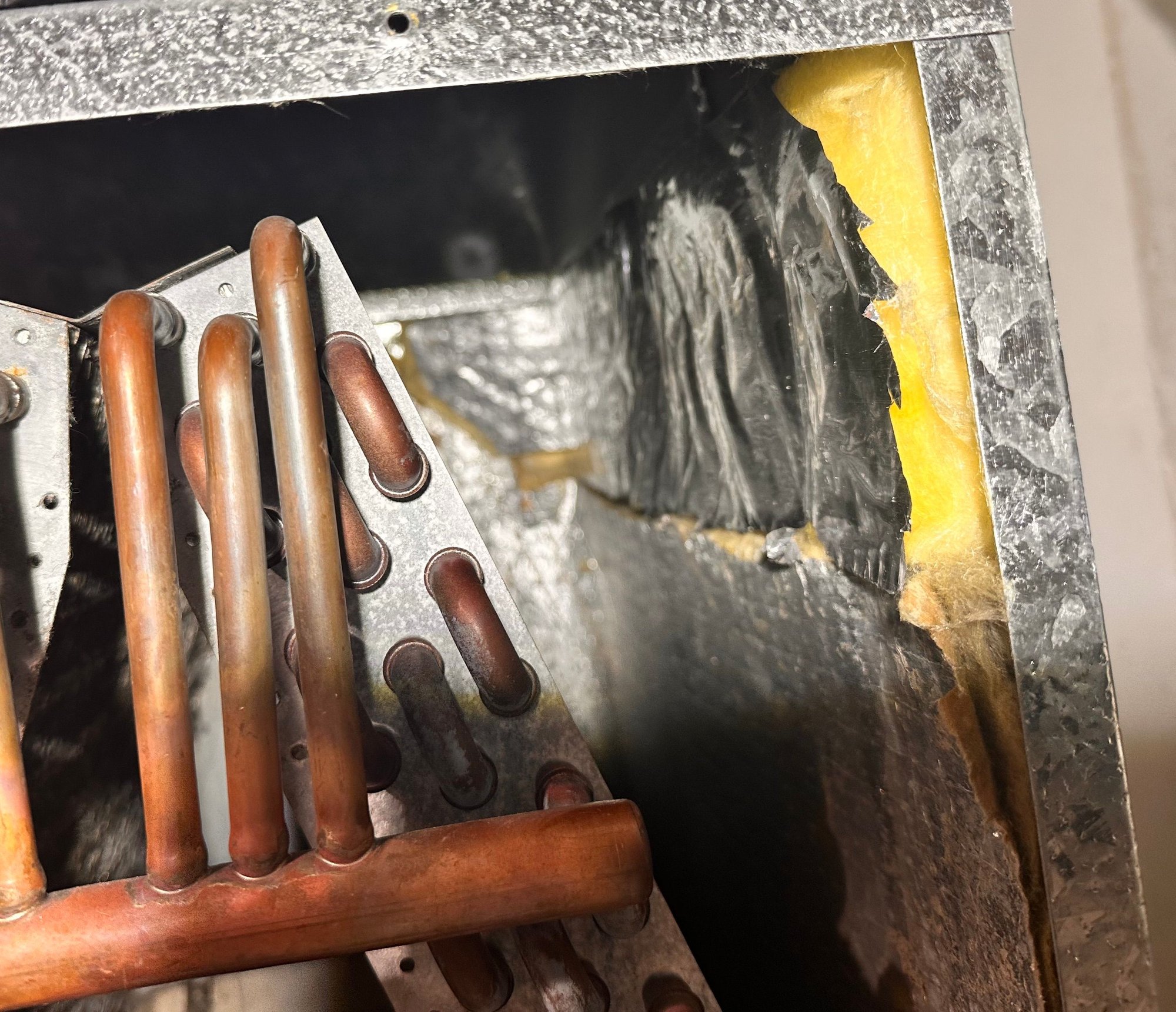 Sealing fibreglass insulation seam in evaporator coil chamber with ...